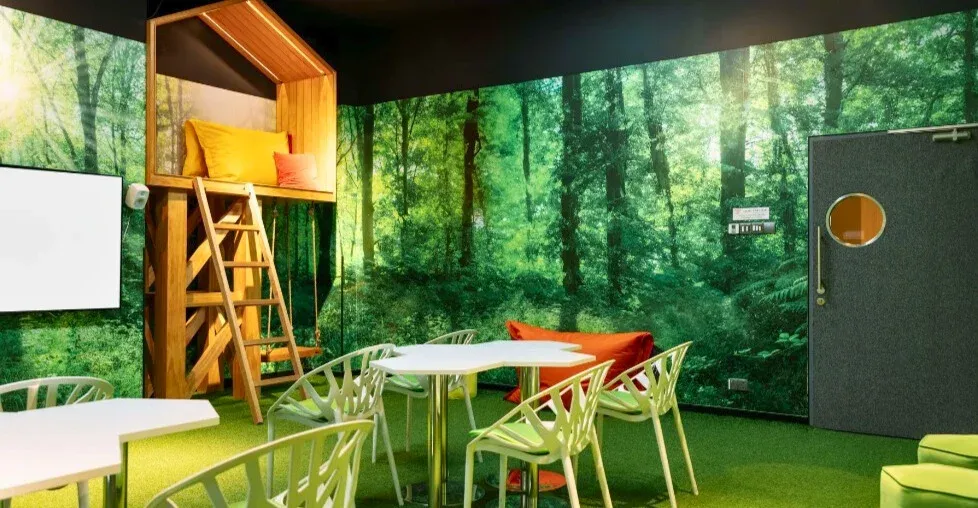 Immersive Biophilic Room With Treehouse and Geometric Tables for Team ...